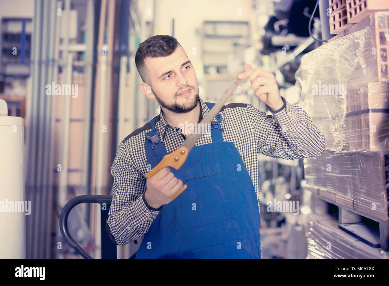 Ordinary male worker showing his working tools at workshop Stock Photo ...