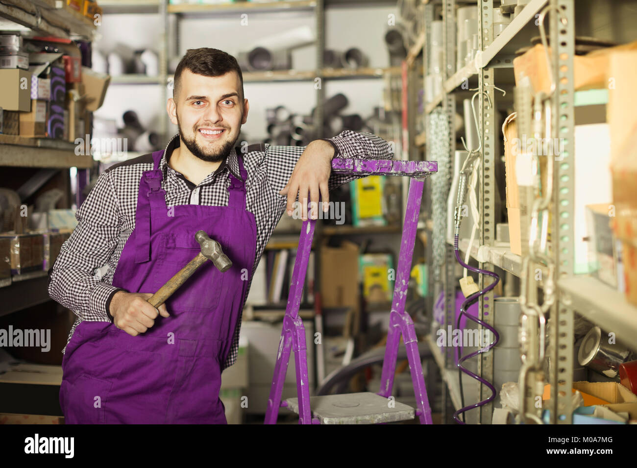 Young worker with a tool in his hands is standing in his workshop Stock ...