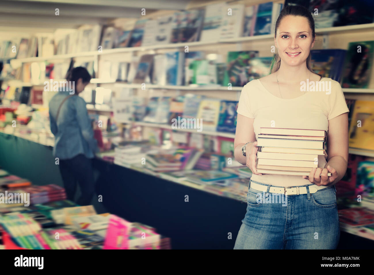 Laughing woman buying books in hard cover in bookstore Stock Photo - Alamy