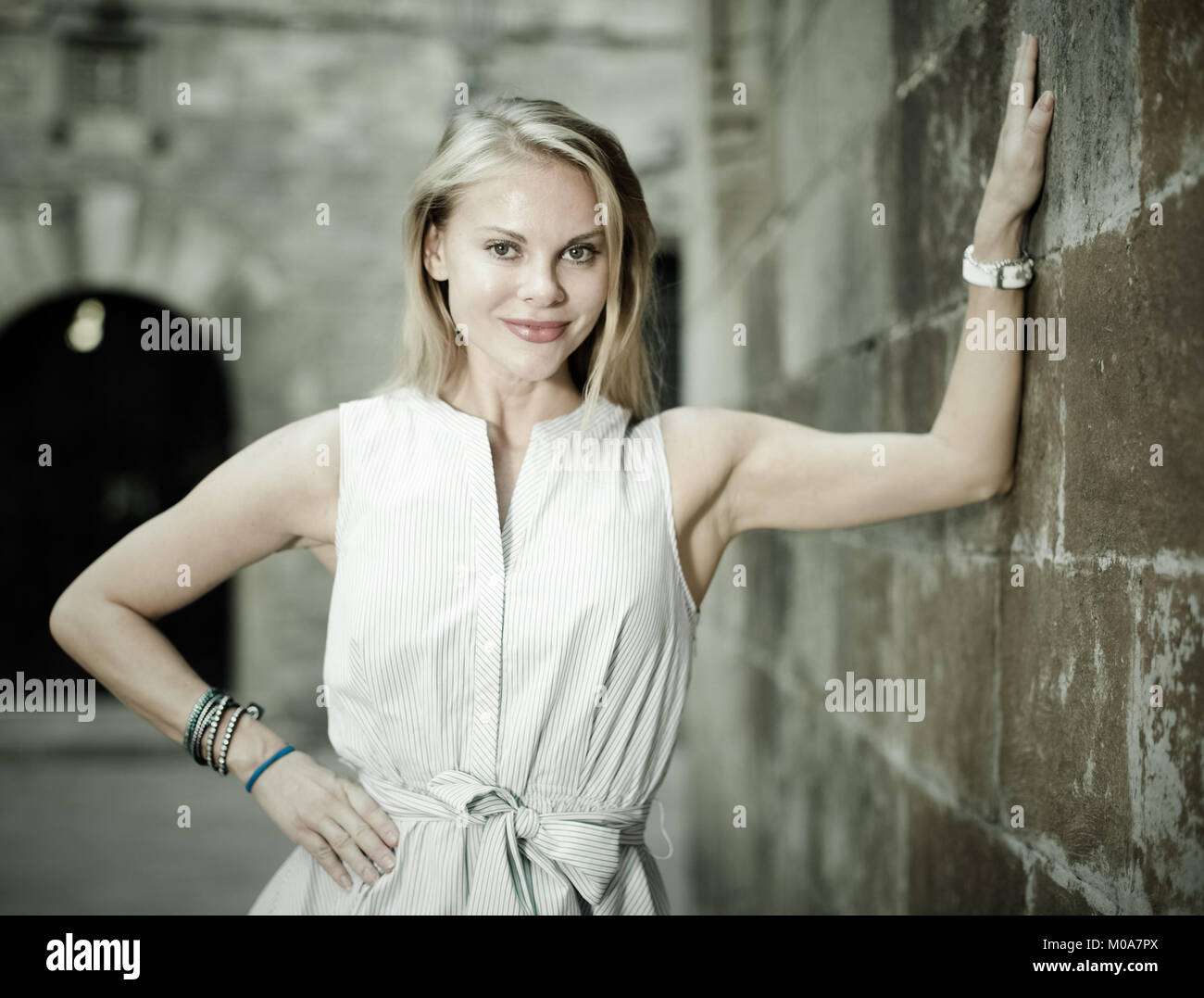 Adult female standing near the stone wall at the street Stock Photo - Alamy