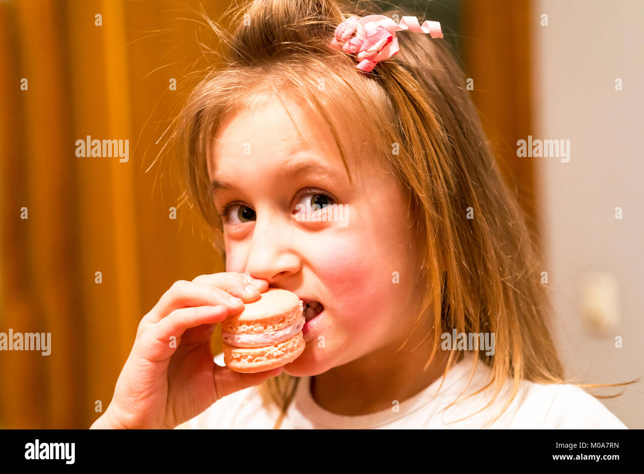 little girl biting a pink cake Stock Photo - Alamy