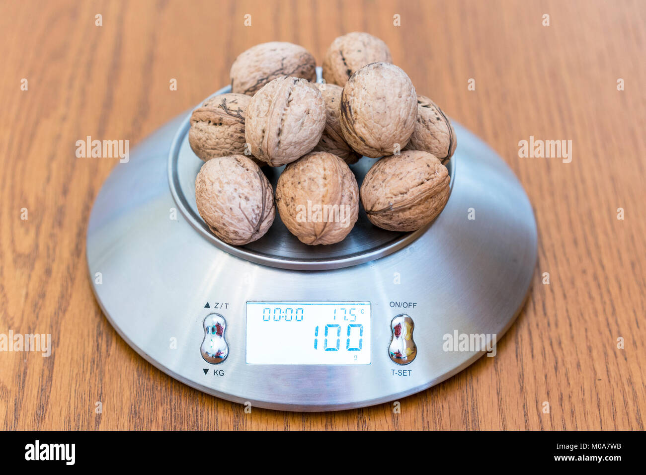 One hundred grams of walnuts on the scales Stock Photo - Alamy
