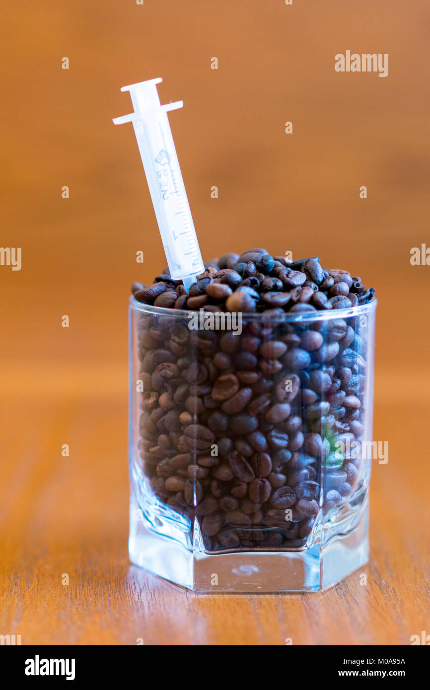 Coffee dependence. Syringe and grains of coffee Stock Photo - Alamy