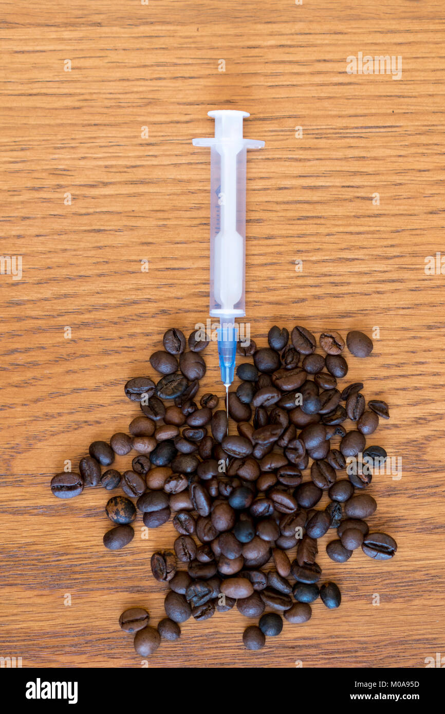 Coffee dependence. Syringe and grains of coffee Stock Photo - Alamy