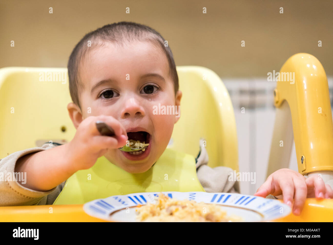 Toddler boy eats rice spoon Stock Photo - Alamy