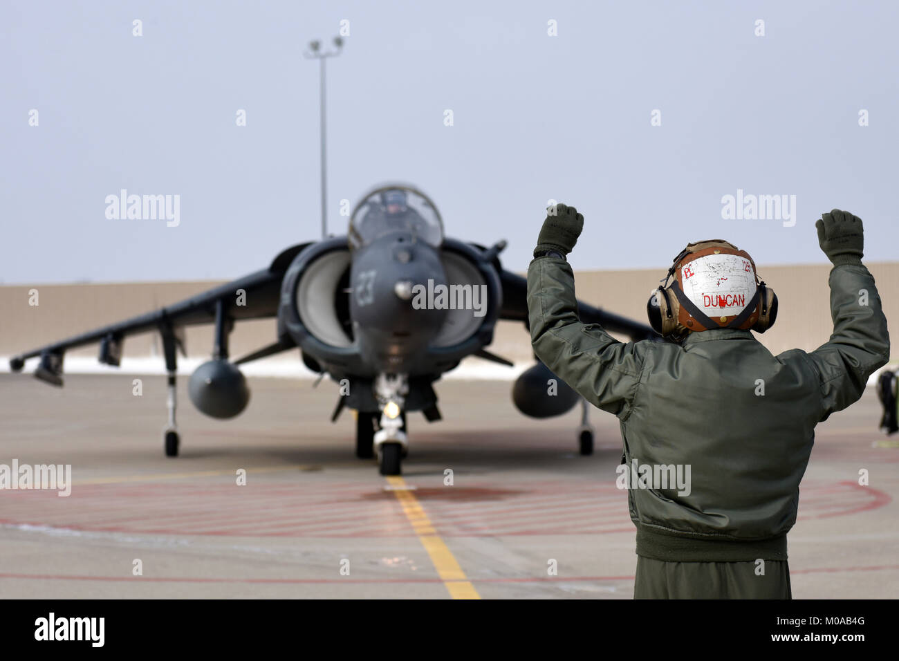 U.S. Marine Corps Capt. Ryan J. Diehl directs an AV-8B Harrier pilot ...