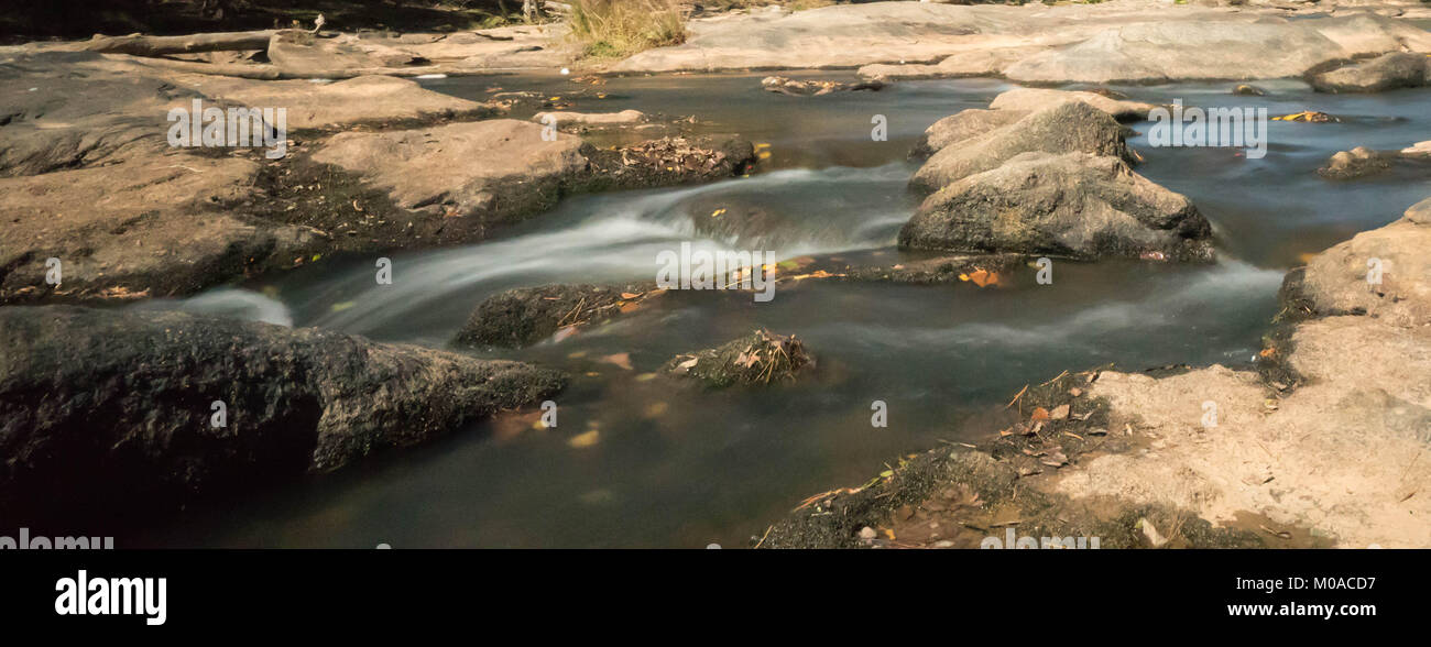 beautiful small creek landscape in late autumn with rocks and flowing ...