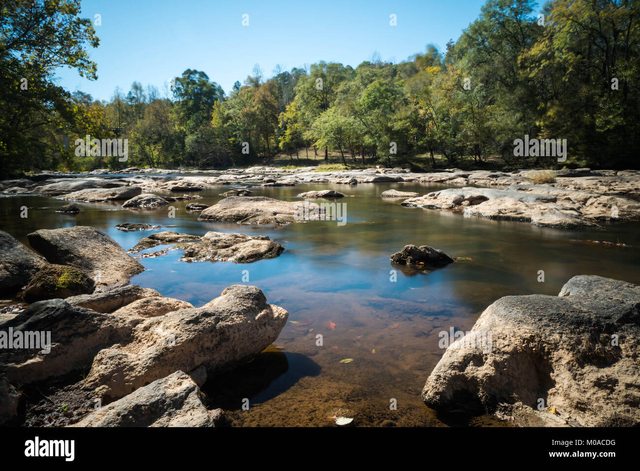 beautiful small creek landscape in late autumn with rocks and flowing ...