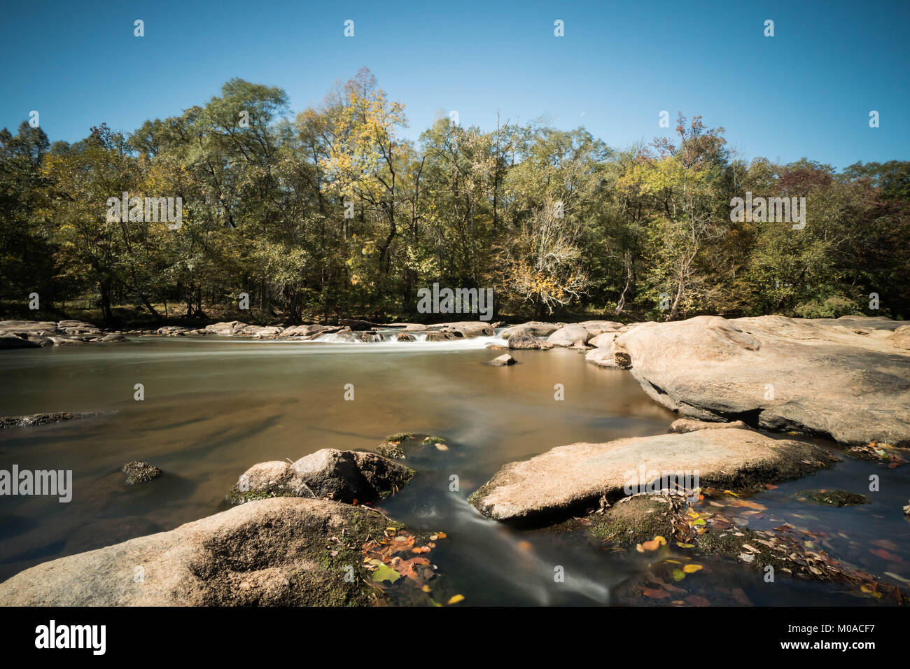 beautiful small creek landscape in late autumn with rocks and flowing ...