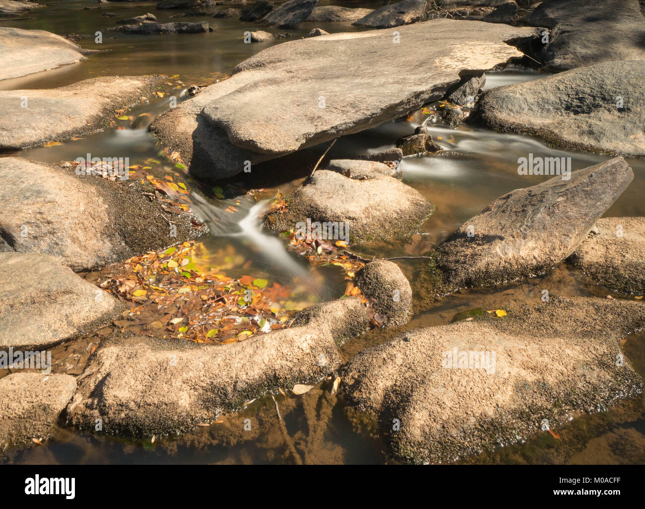 beautiful small creek landscape in late autumn with rocks and flowing ...