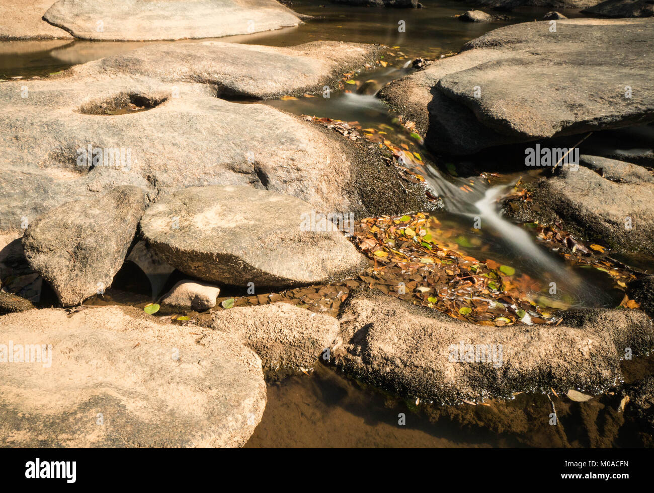 beautiful small creek landscape in late autumn with rocks and flowing ...
