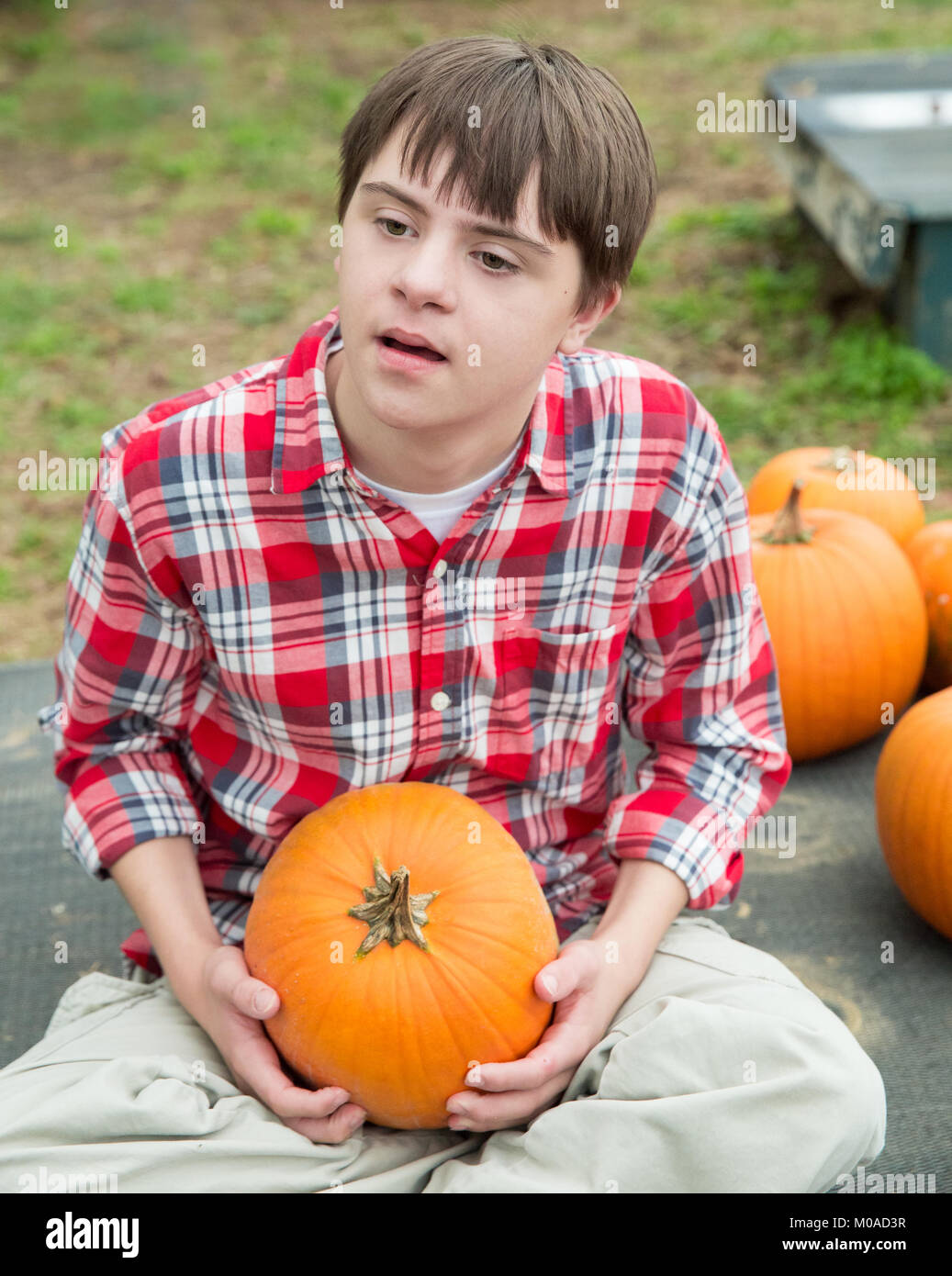 Attractive Boy with Down's Syndrome and Autism, holding a pumpkin Stock ...