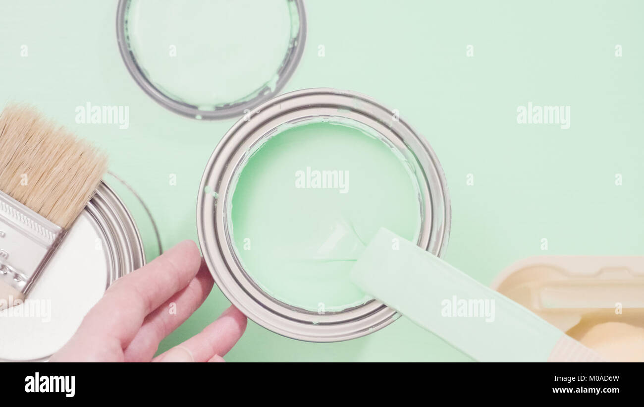 Mixing paint in metal paint can with wooden stick Stock Photo - Alamy