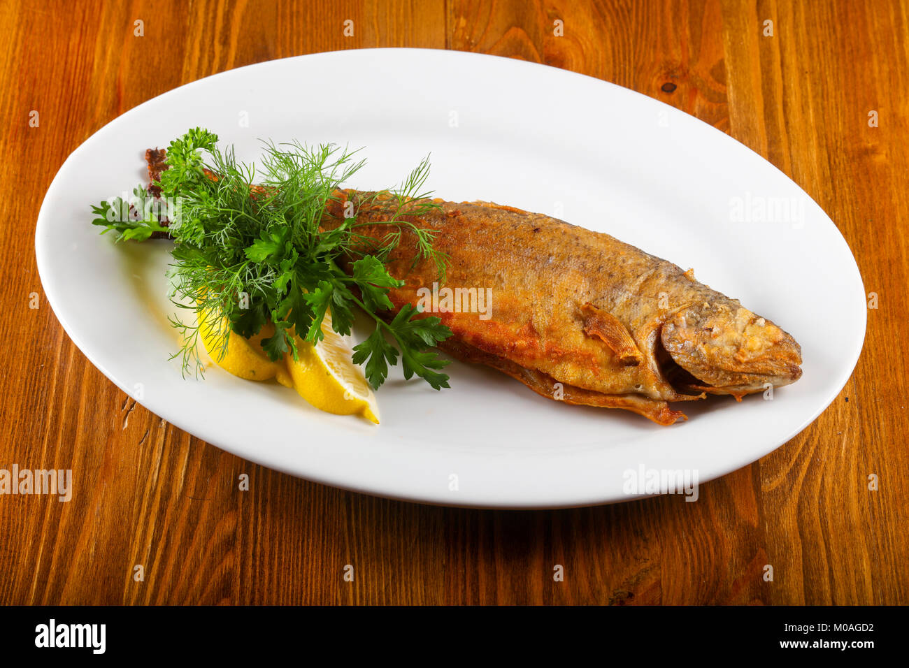 Roasted trout served lemon and herbs Stock Photo - Alamy