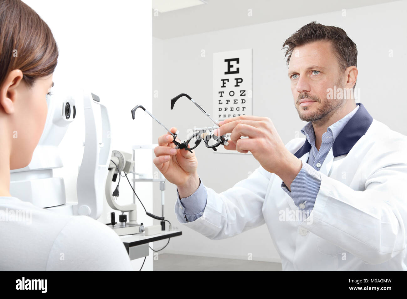 optometrist with trial frame examining eyesight woman patient in optician office Stock Photo - Alamy