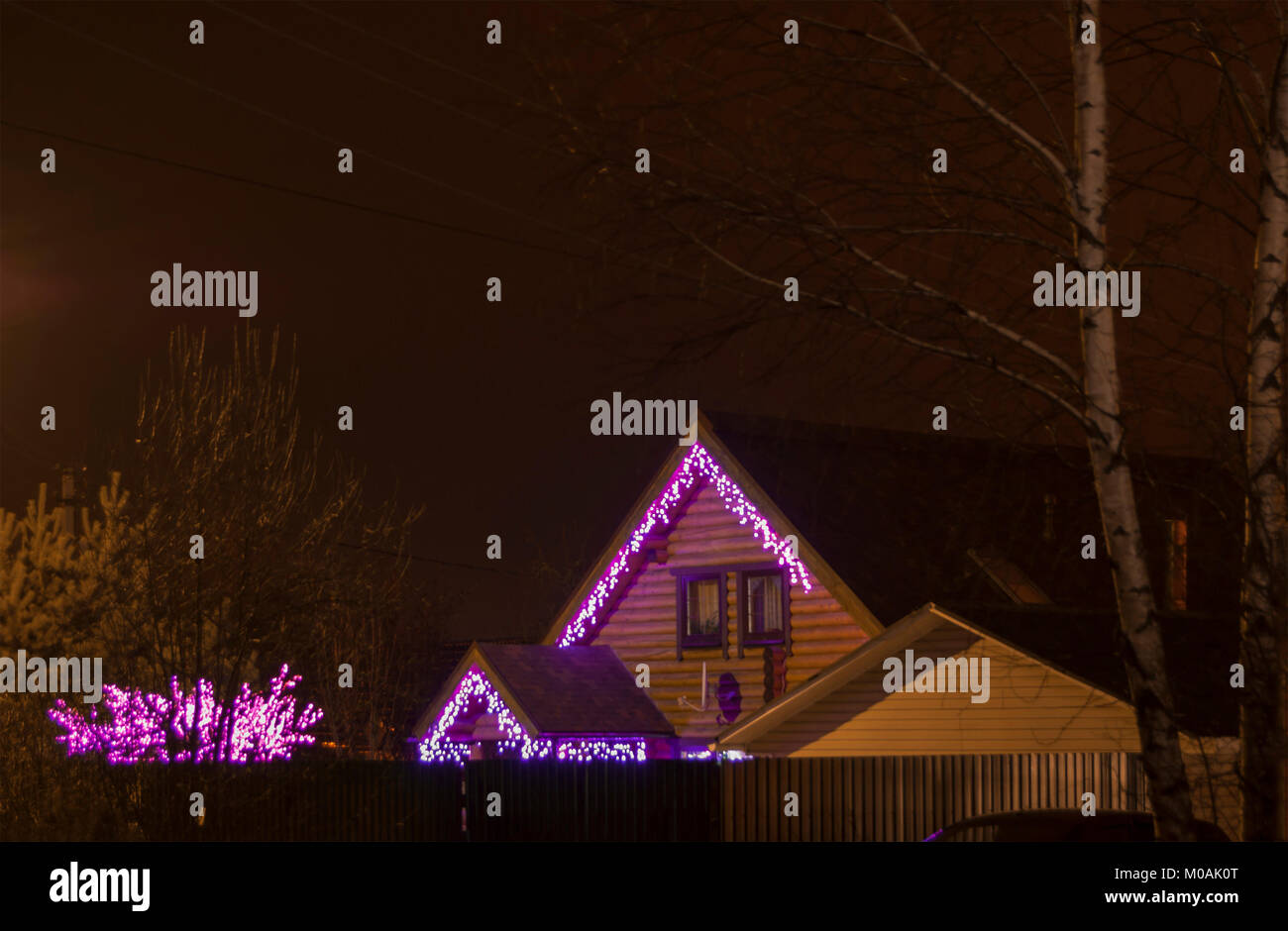 Village house on the street, decorated with garlands for Christmas ...