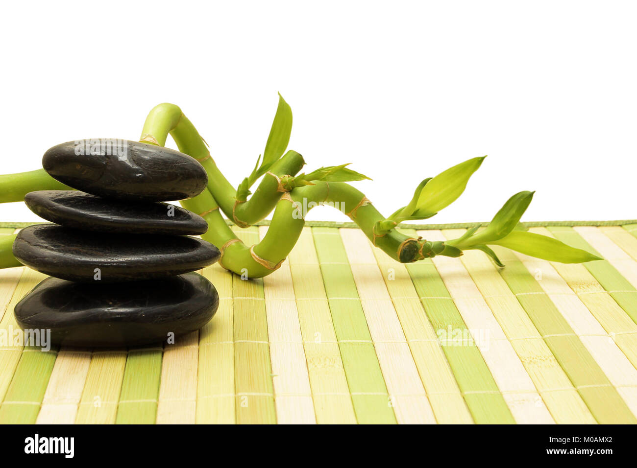 green bamboo and four stones on mat Stock Photo - Alamy