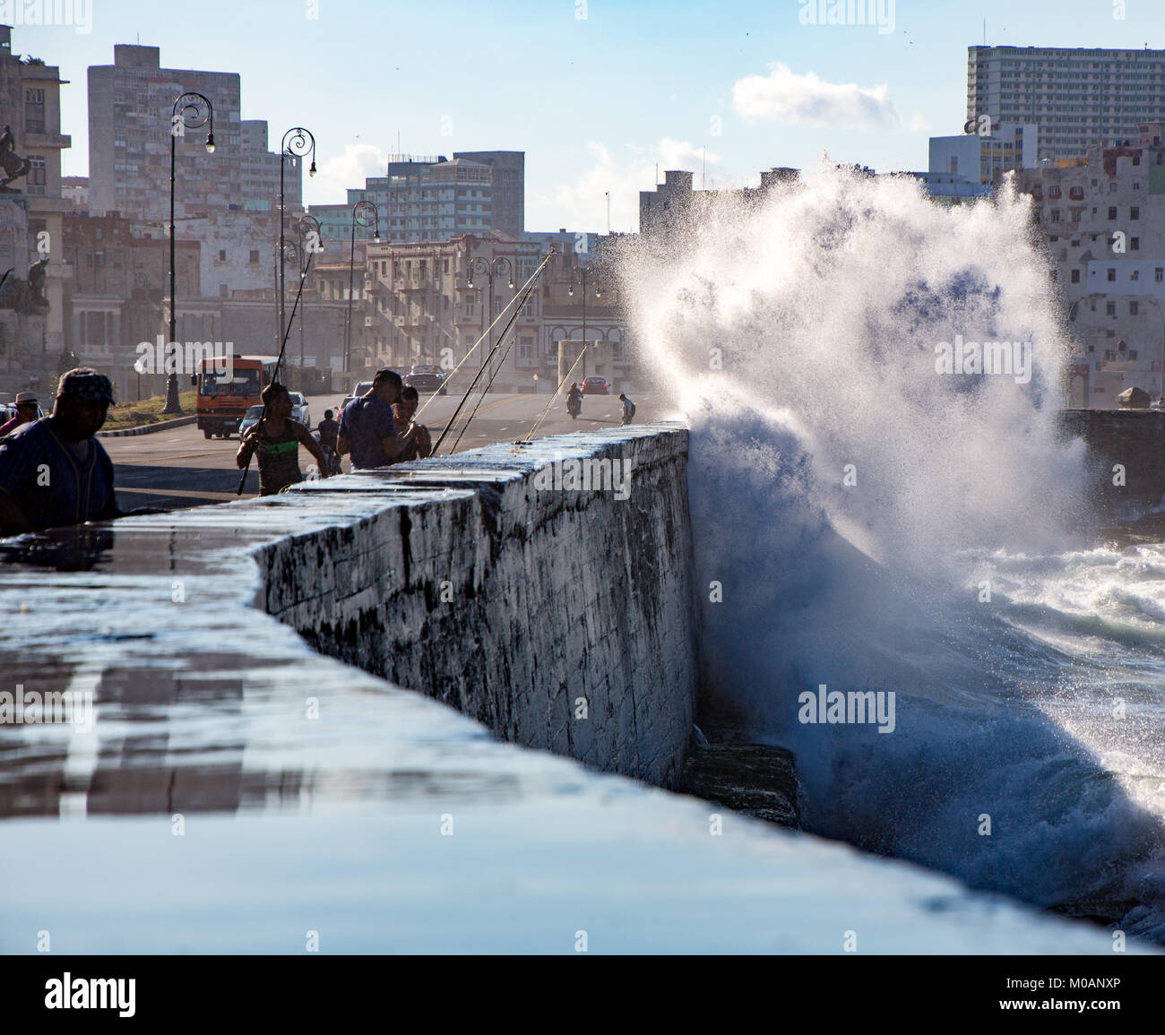 Havana, Cuba, Nov 20, 2017 - Waves crash over the Malecon wall as men ...