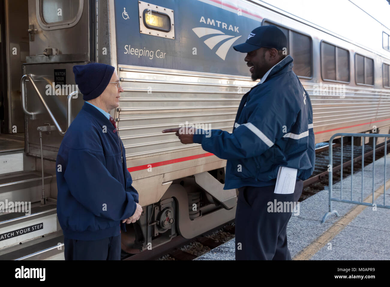 Two male Amtrak porter employees having a conversation while at a ...