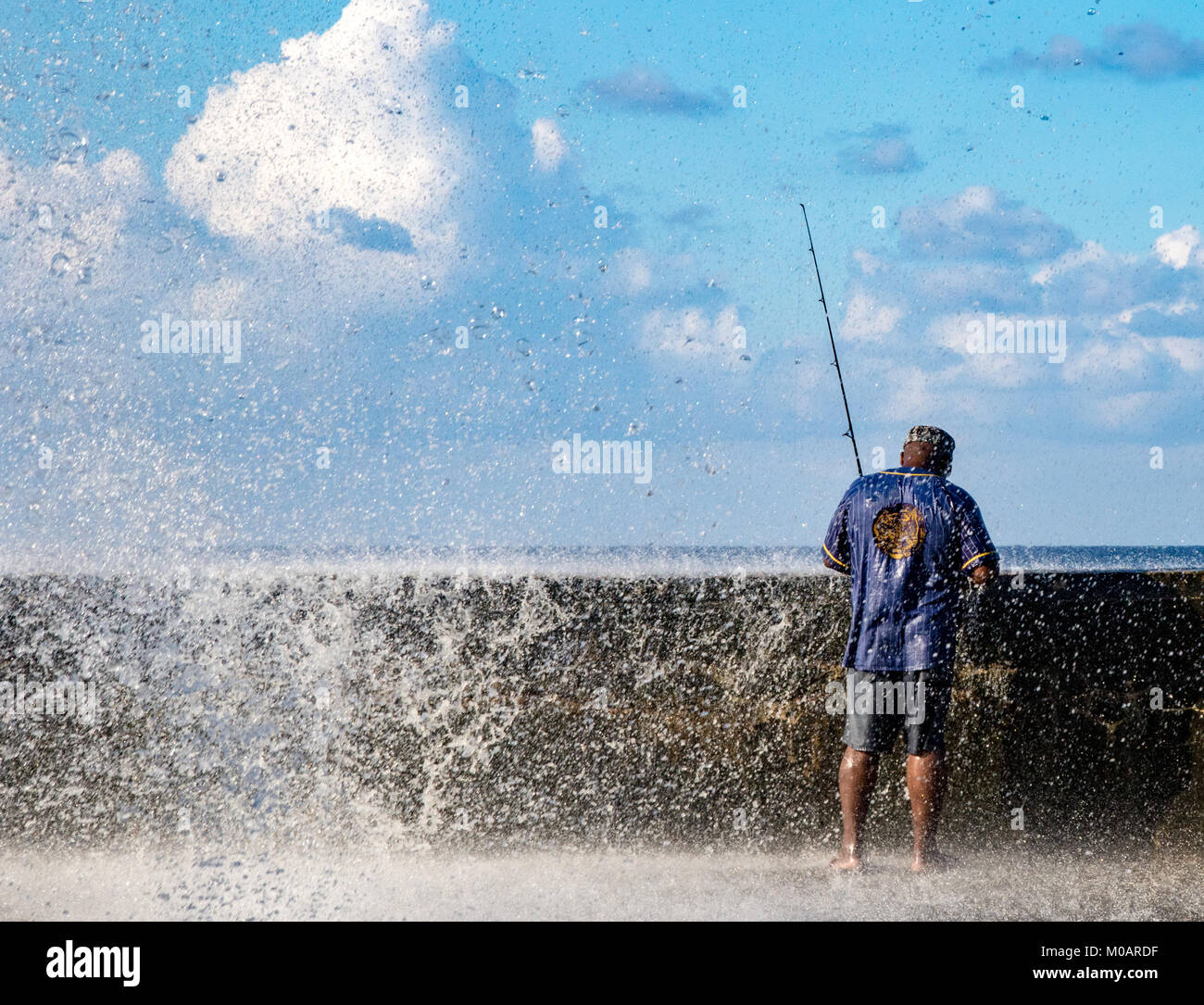 Havana, Cuba, Nov 20, 2017 - Waves crash over the Malecon wall as men ...
