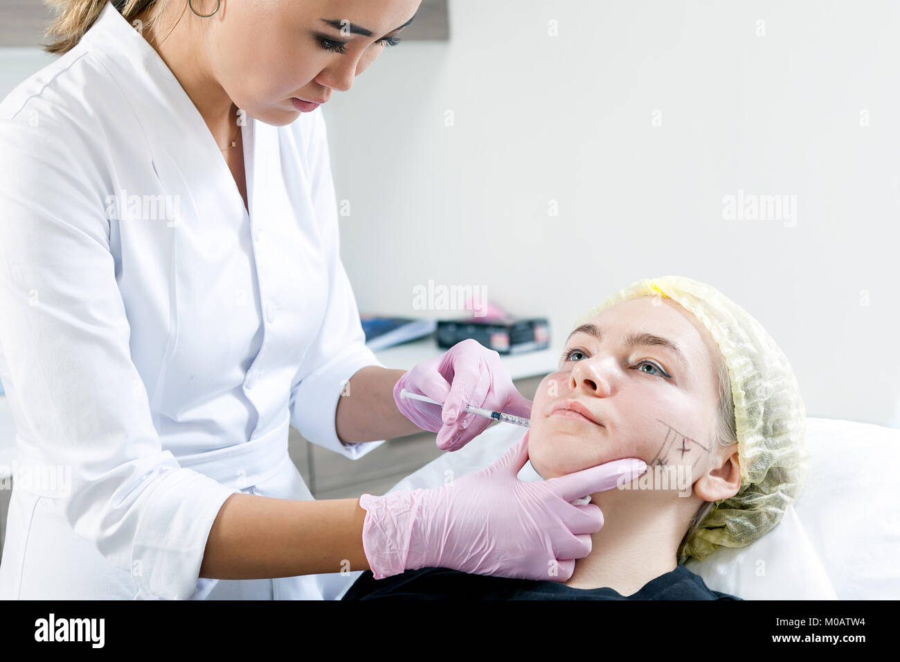 Close-up Young woman azitka doctor cosmetician in white lab coat and ...