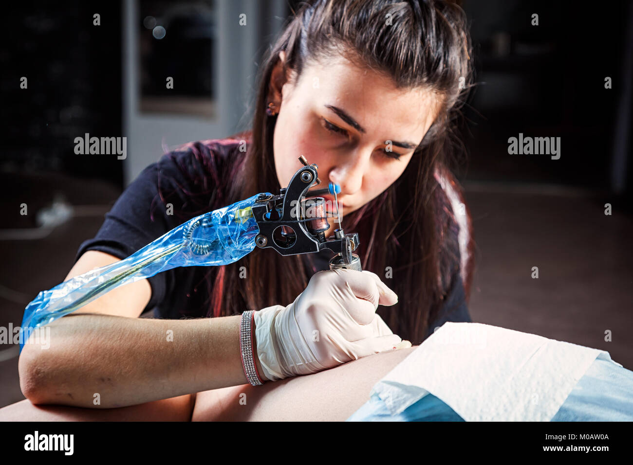 Tattooist making by professional artist is tattooing body woman using ...