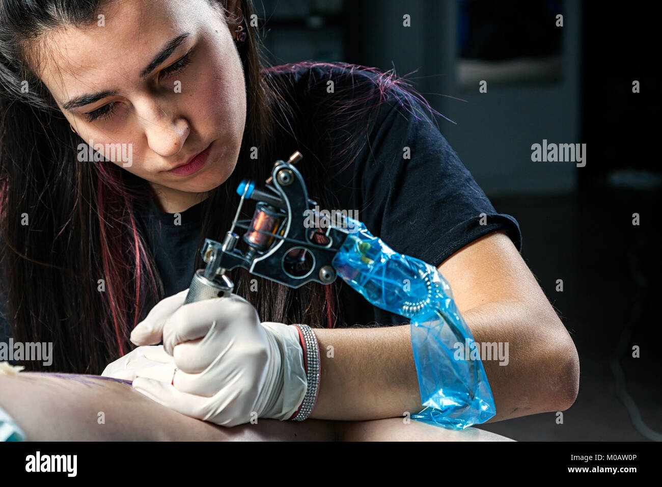 Professional tattoo artist makes a tattoo on the femur Stock Photo - Alamy