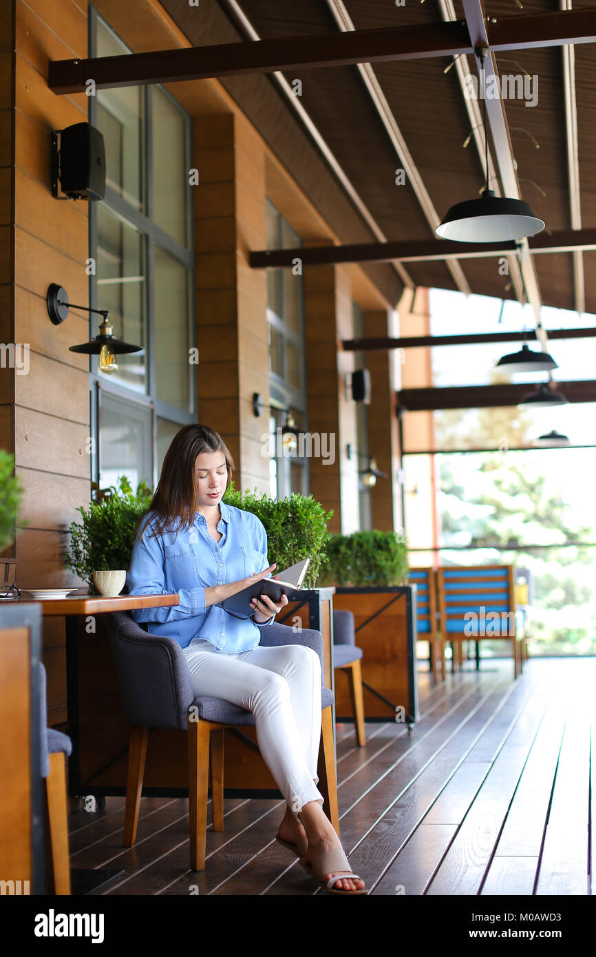 Beautiful girl reading diary at cafe Stock Photo - Alamy