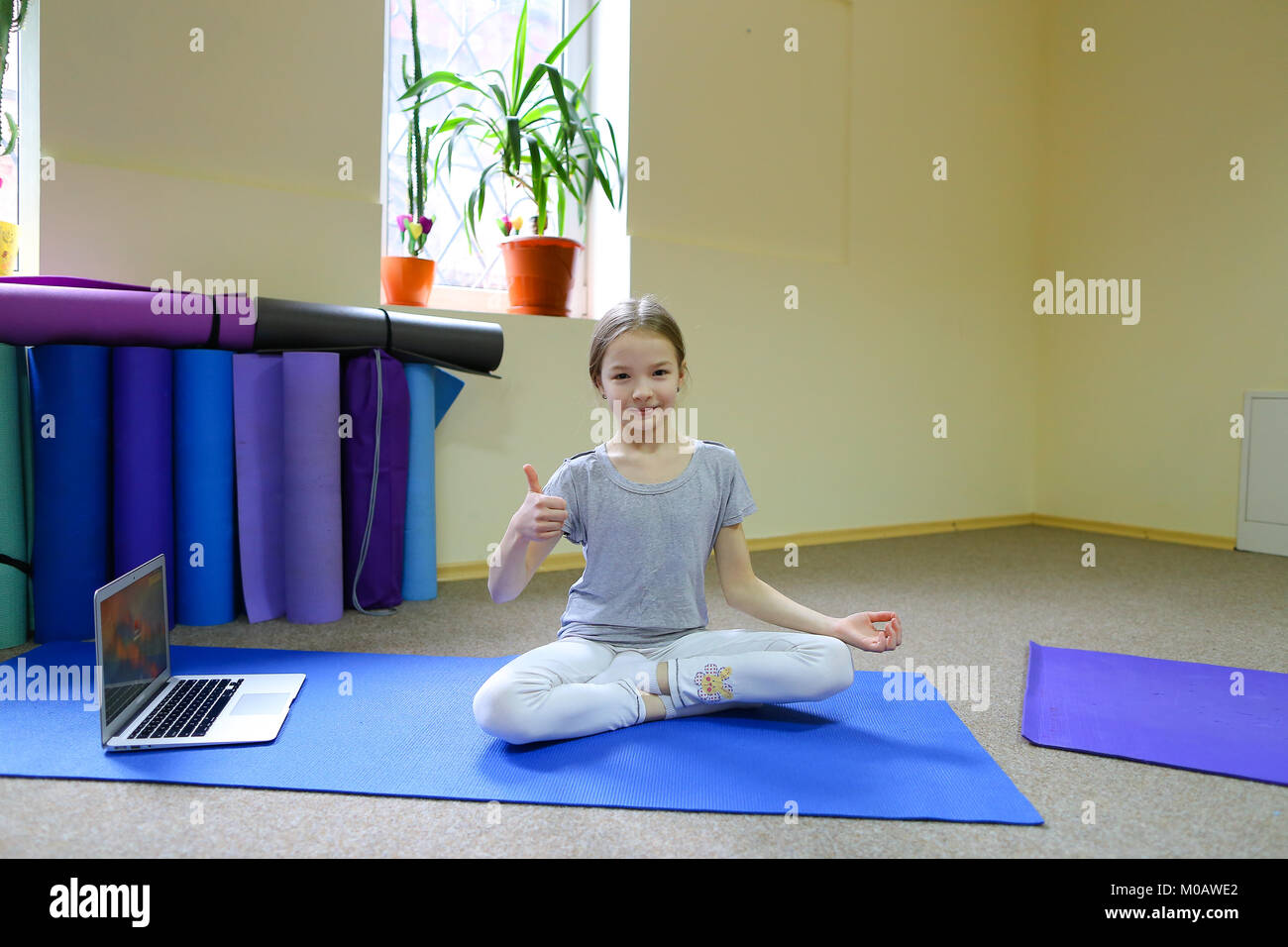 Little girl sits on floor in lotus position Stock Photo - Alamy