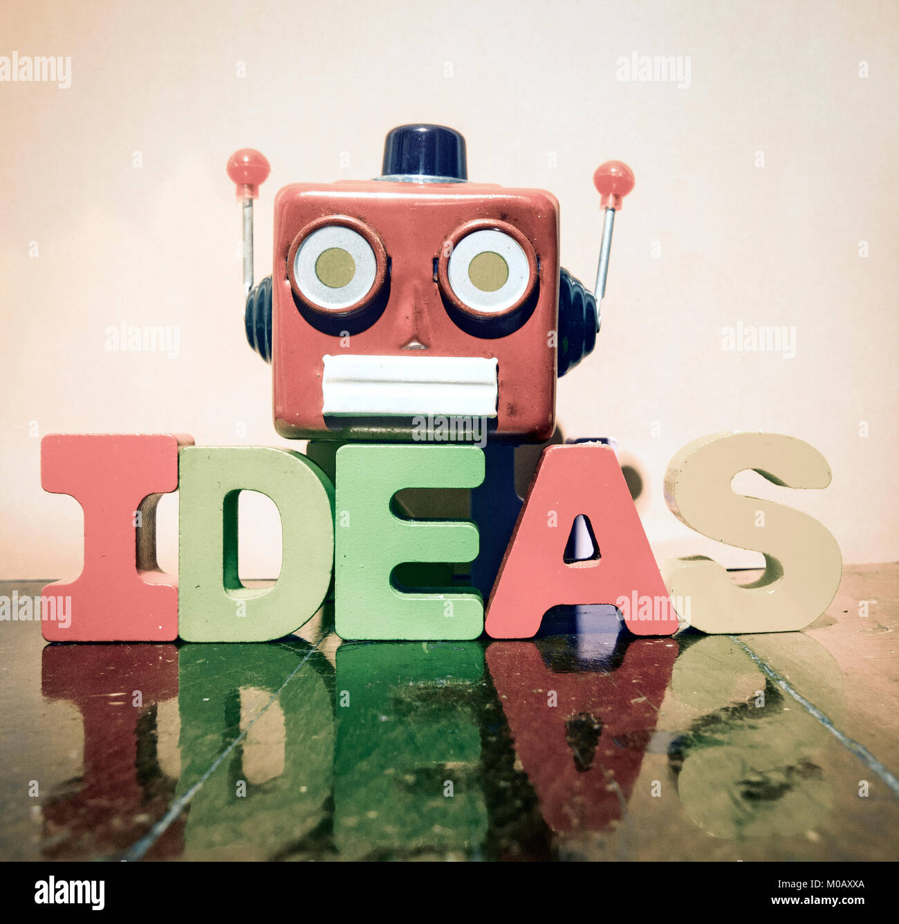 red robot head on wooden letters that say IDEAS on an old wooden floor ...