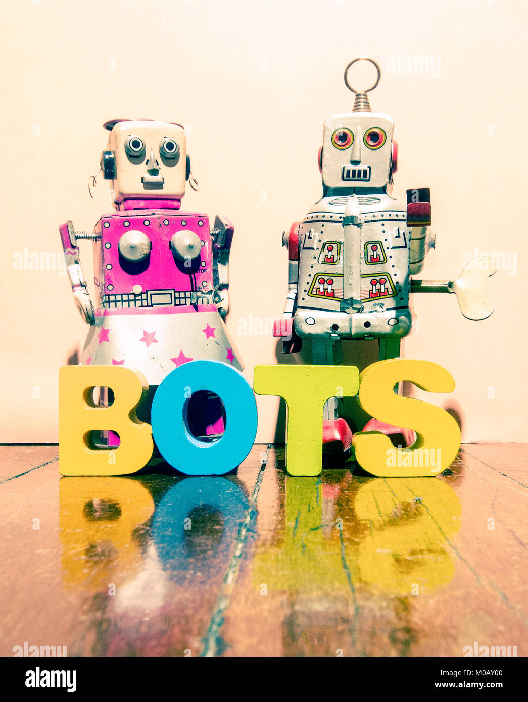 two retro robot toys and the word BOTS on a wooden floor Stock Photo - Alamy