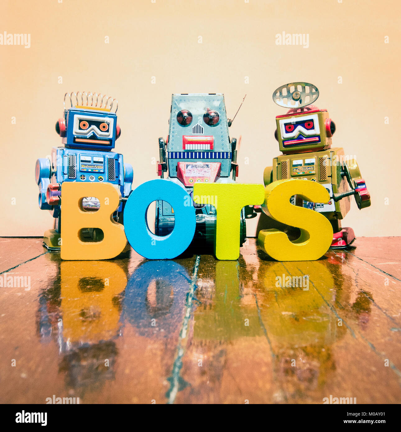 three retro robot toys and the word BOTS on a wooden floor Stock Photo ...