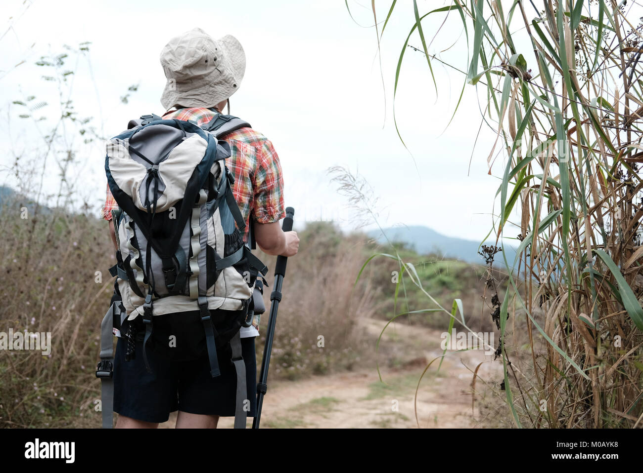 traveler hiker man with backpack hiking on mountain. tourist backpacker ...