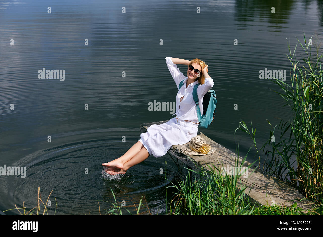 Young woman resting near lake Stock Photo - Alamy