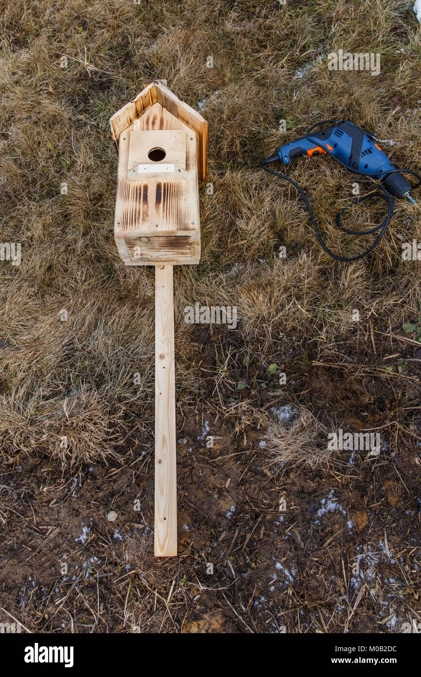 Installation of the birdhouse on the pillar Stock Photo - Alamy