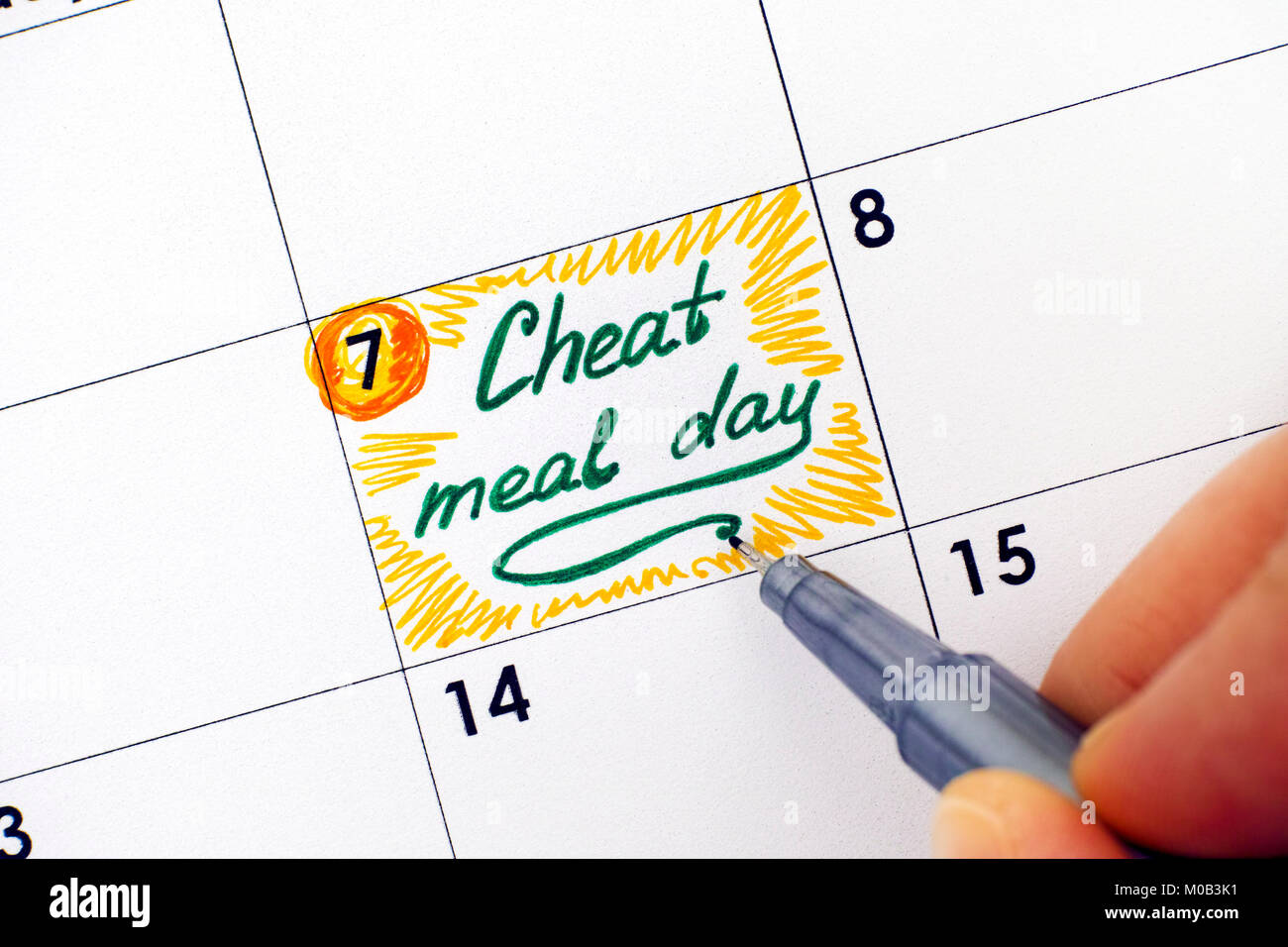 Woman hand with pen writing reminder Cheat Meal Day in calendar. Close ...