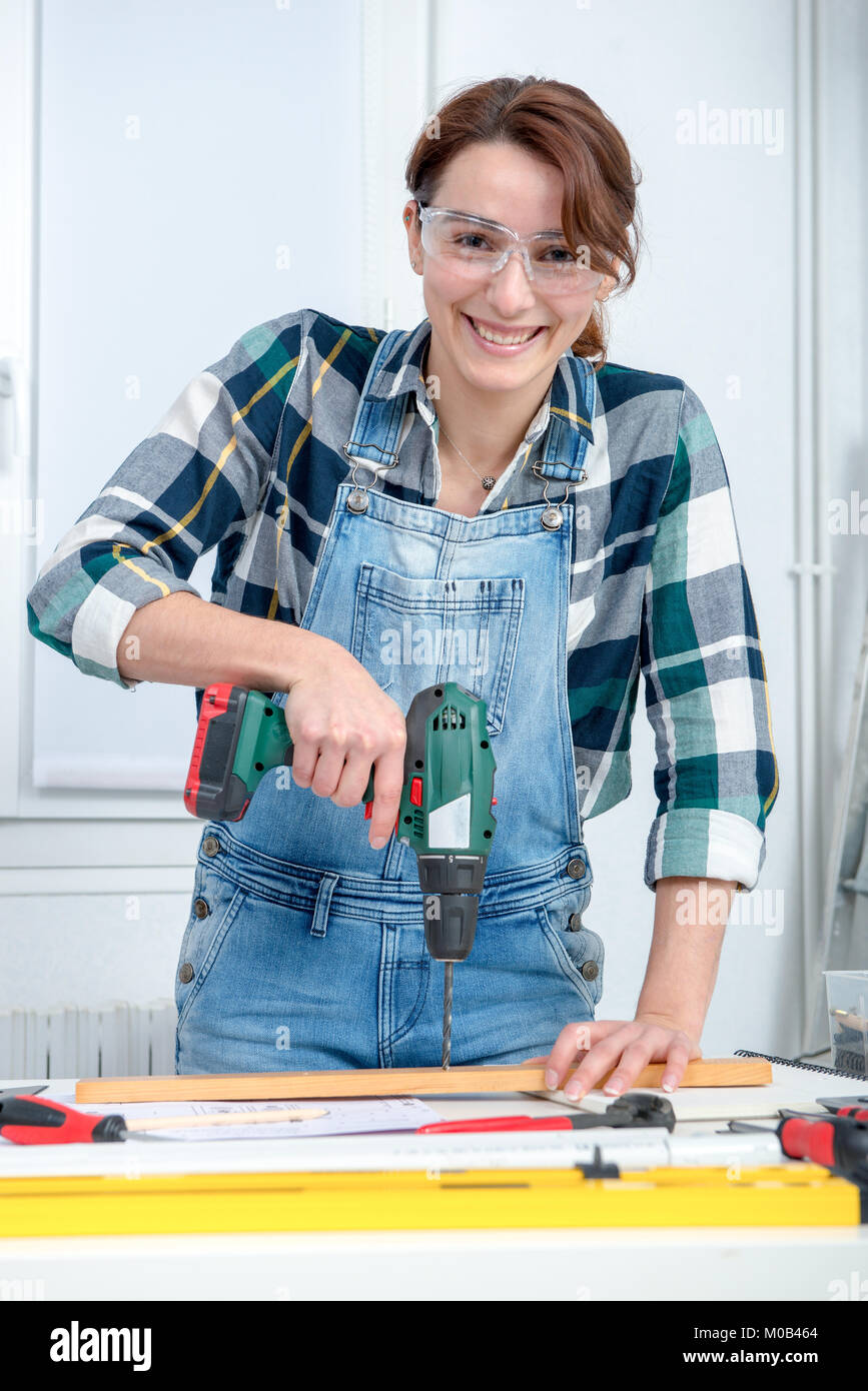 Woman builder using drill hi-res stock photography and images - Alamy