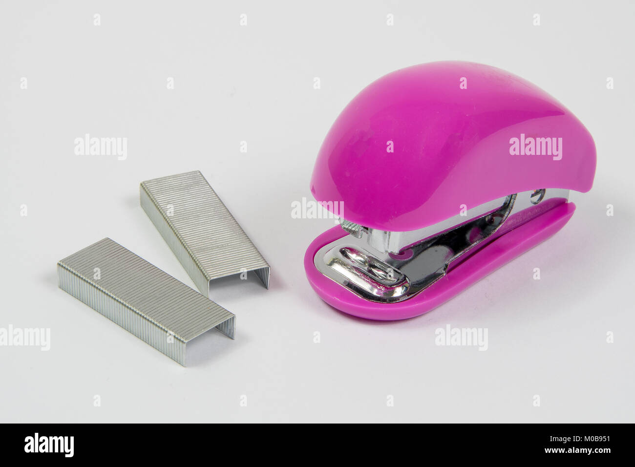 Small Pink Stapler with staples on a white background Stock Photo - Alamy