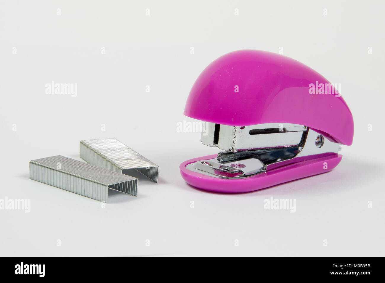 Small Pink Stapler with staples on a white background Stock Photo - Alamy