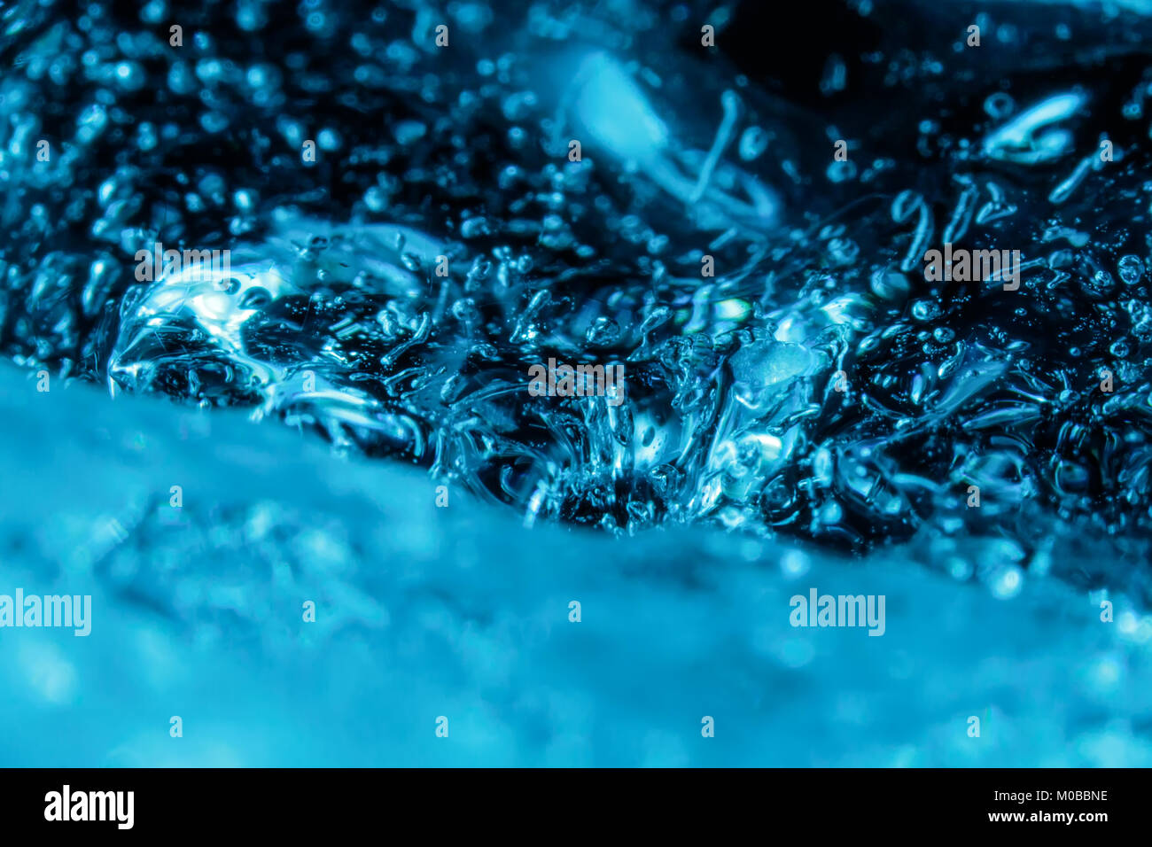 Turquoise ice with frozen bubbles in the water. A small iceberg in the ...