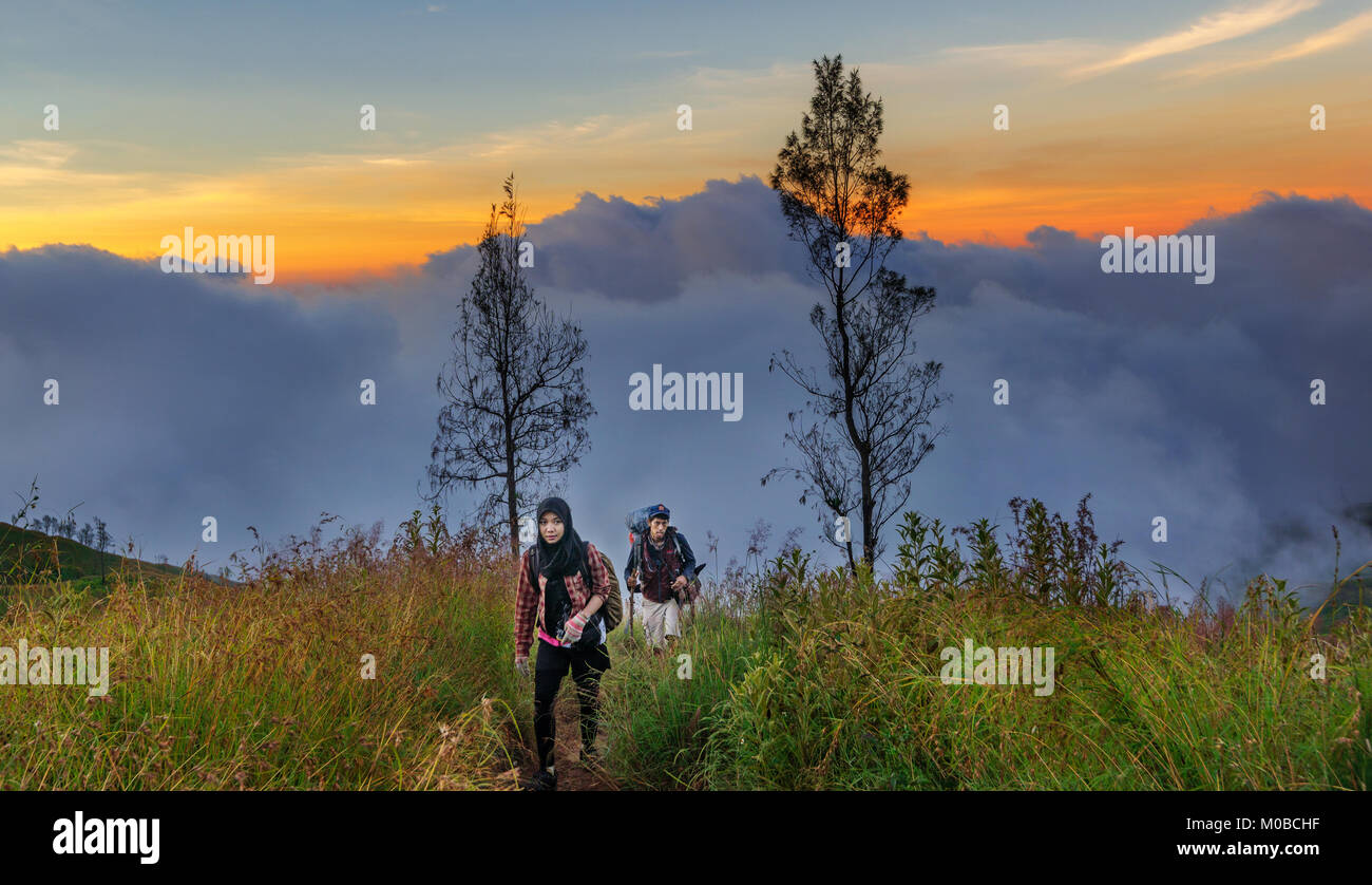 Couples trekking mountain to reach summit, Rinjani, Indonesia Stock ...