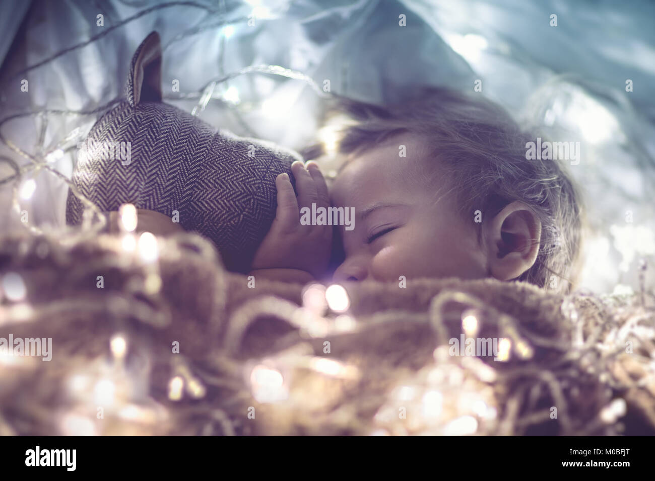 Sweet little baby sleeping with soft toy in the bed at home, smiling in ...