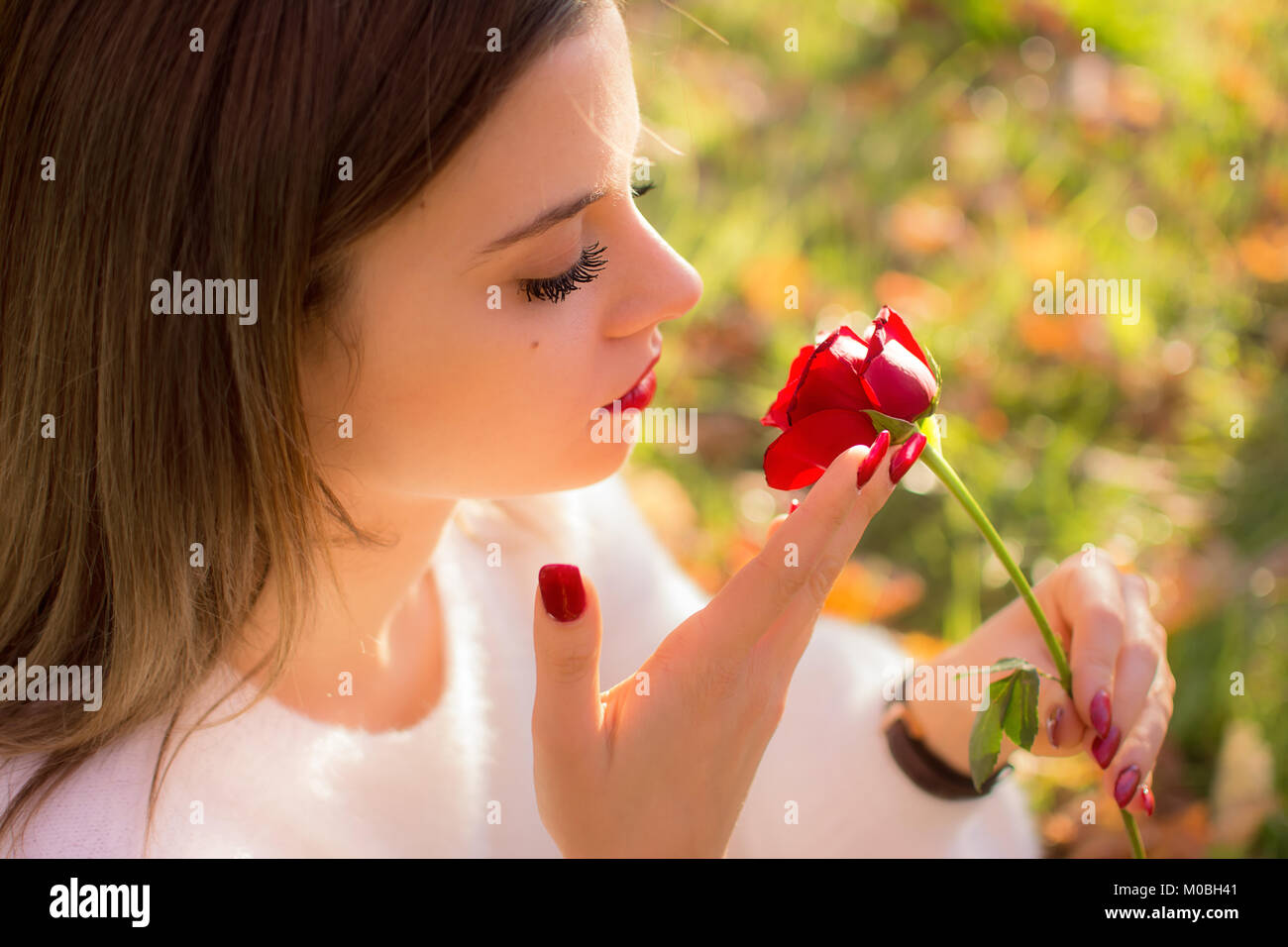 A Girl sniffing a red rose in San Valentine day Stock Photo - Alamy