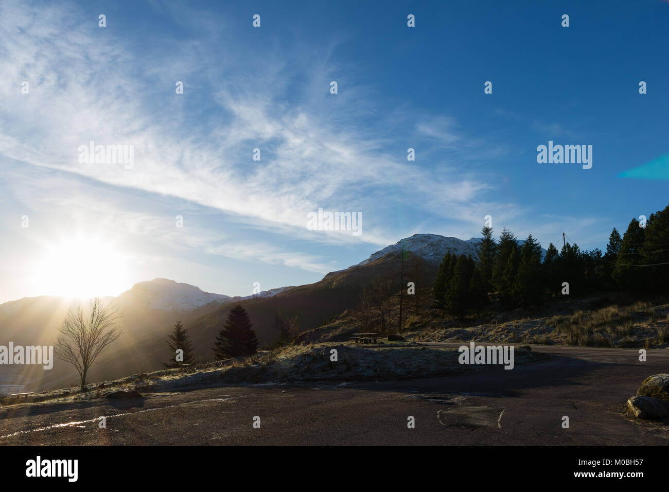 The sun slowly rising above the hillside Stock Photo - Alamy