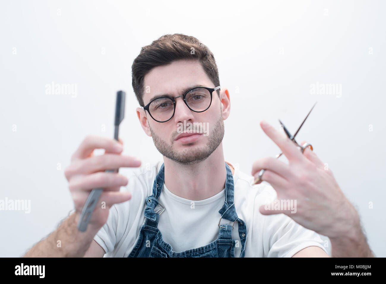 Barber keeps scissors and a razor against the background of a white ...