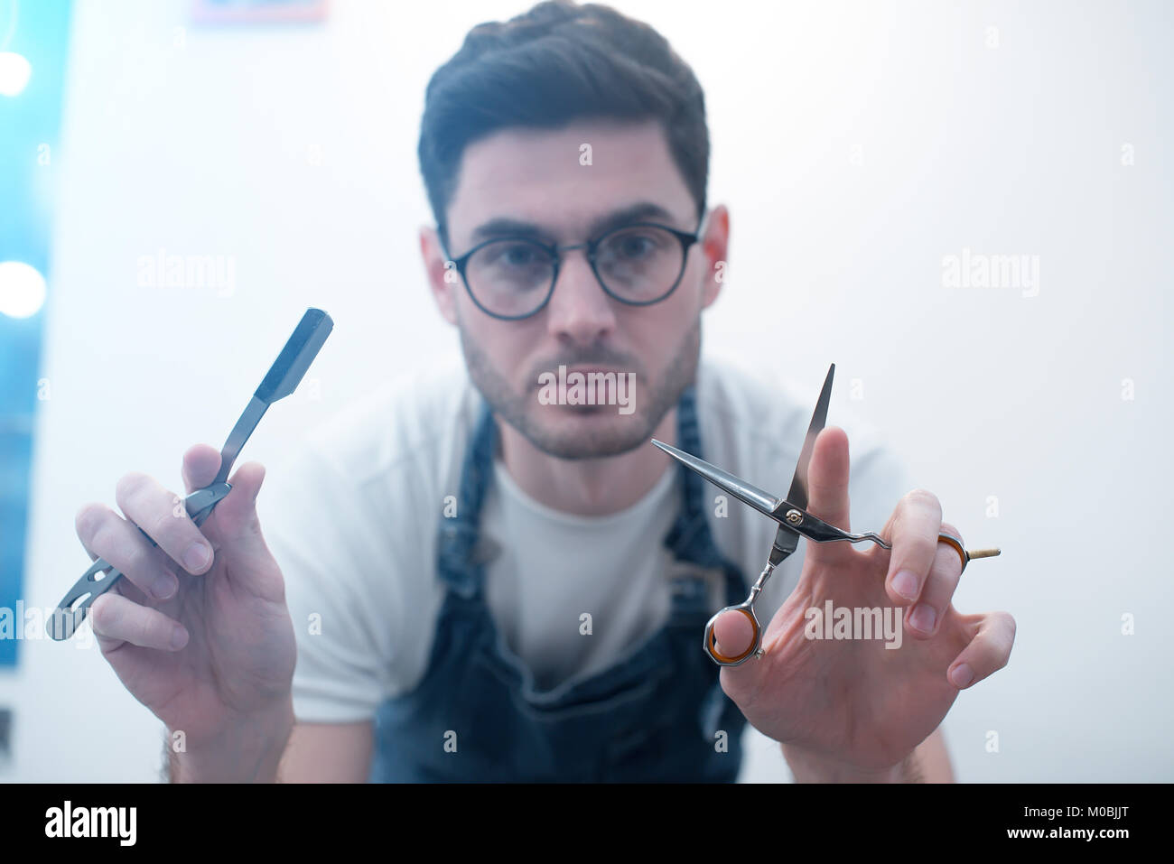 Barber keeps scissors and a razor against the background of a white ...