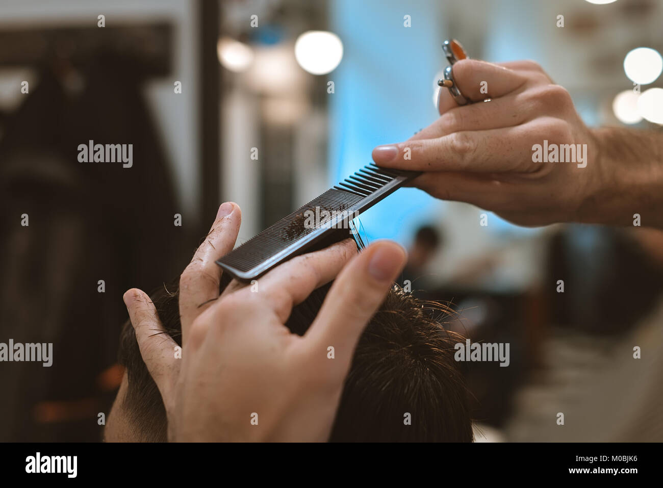 Closeup of happy man getting an haircut from barber in hair salon Stock ...