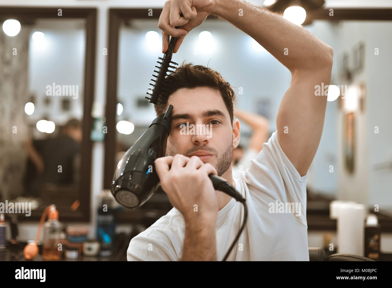 The guy dry and lay his hair. Portrait of a great layout in the beauty ...