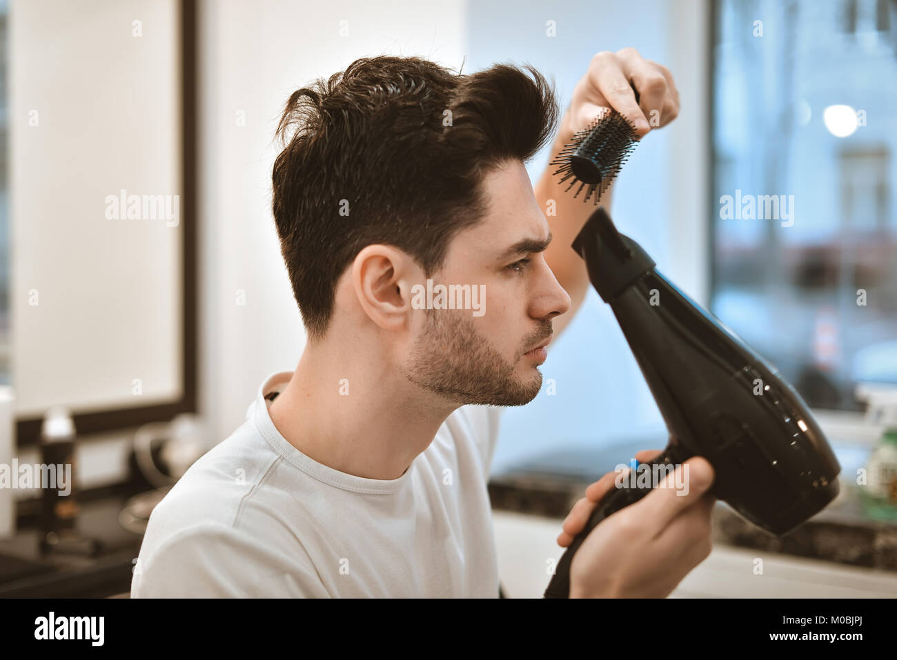 The guy dry and lay his hair. Portrait of a great layout in the beauty ...