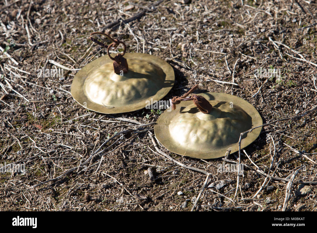 Golden ancient cymbals on the ground. Concave hemispherical discs used ...